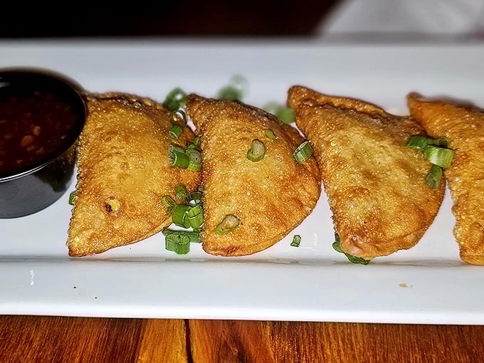 Duck wontons lined up like little crispy soldiers, ready to march straight into flavor battle with that tangy dipping sauce as their secret weapon.