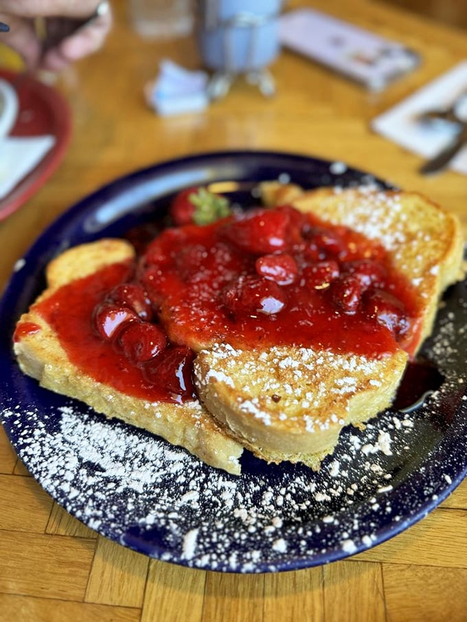 French toast that's living its best life under a blanket of strawberry compote—the breakfast equivalent of wearing pajamas to a five-star hotel.