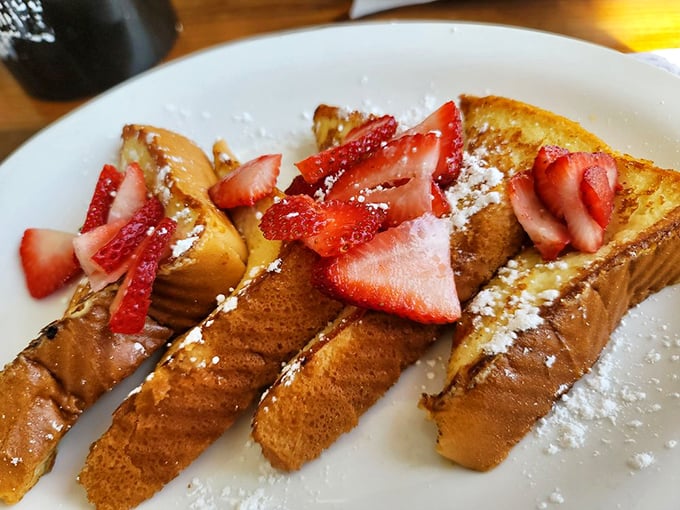 French toast that actually remembers it's supposed to be custardy inside. Those strawberries aren't garnish—they're essential supporting actors.