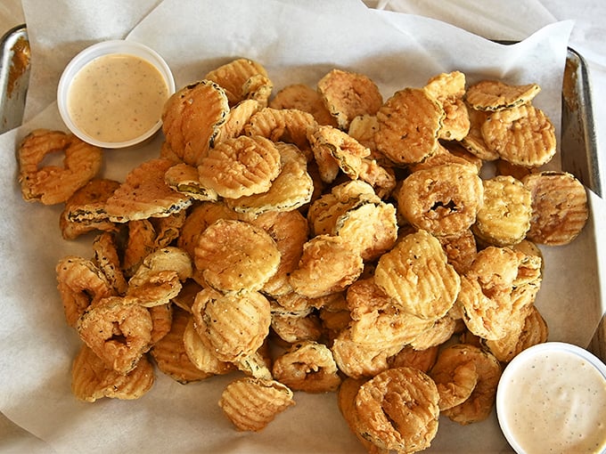 These fried pickles aren't just appetizers—they're conversation starters, served with a dipping sauce that makes you wonder why you'd eat pickles any other way.