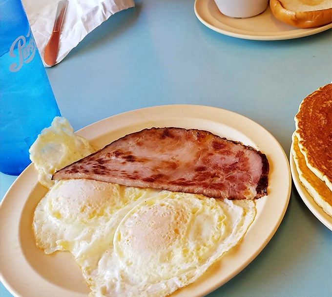 Ham and eggs—the Fred Astaire and Ginger Rogers of breakfast, dancing together in perfect harmony on this no-nonsense white plate.