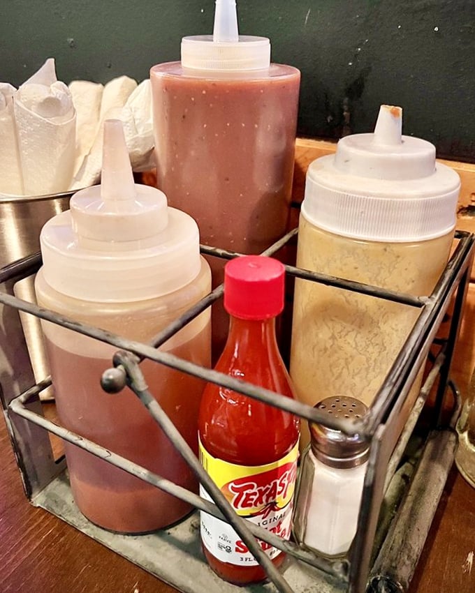 The sauce caddy—where vinegar, tomato, and mustard-based options peacefully coexist, proving barbecue diplomacy is possible after all.