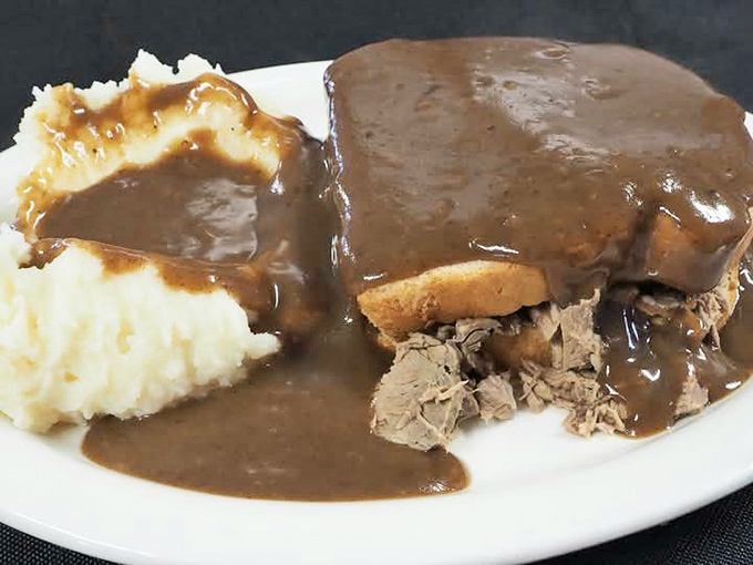 The hot roast beef sandwich – a masterpiece of tender meat, bread foundation, and gravy lava flow that makes mashed potatoes into edible islands.