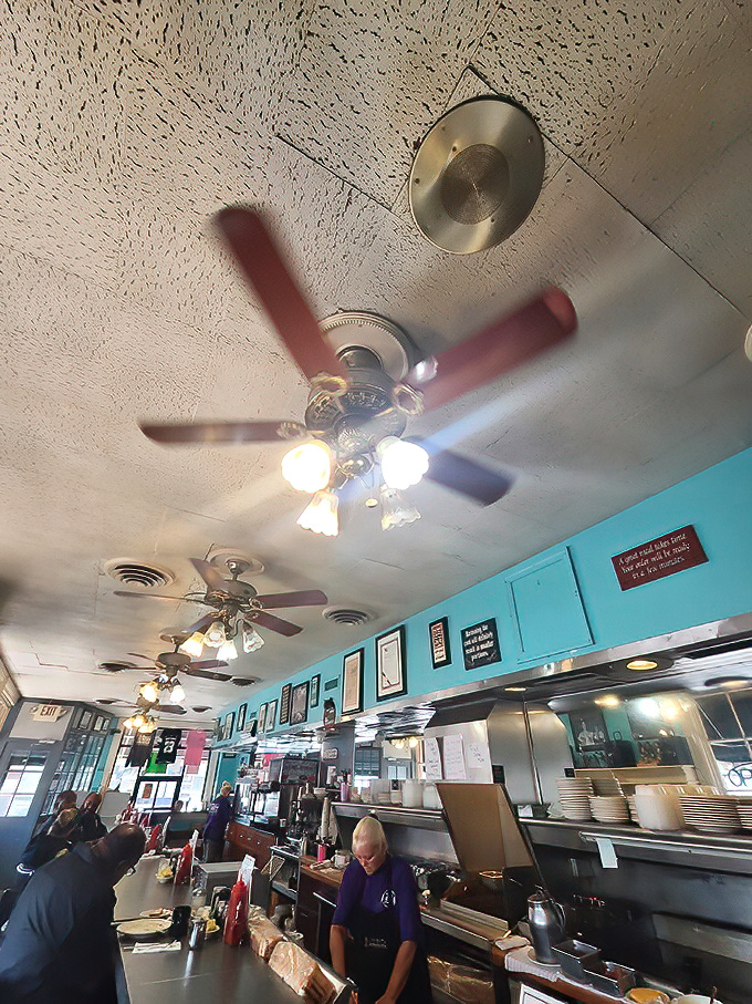 Ceiling fans spin stories overhead while the turquoise walls hold decades of Baltimore breakfast memories. Diners focus on what matters most—the plates before them.