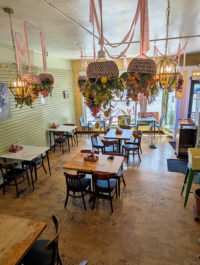 Wicker basket chandeliers draped with flowers create a whimsical canopy over diners—like breakfast under a botanical big top.