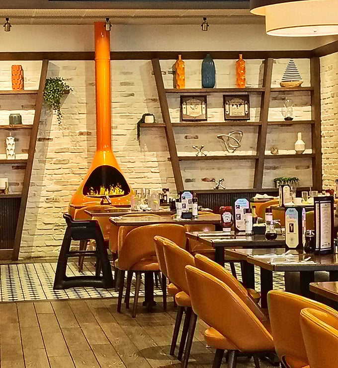 That striking orange fireplace isn't just decor—it's the soul of the room, surrounded by shelves that tell stories of design and comfort.