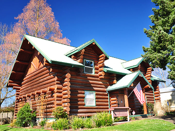 This stunning log cabin museum looks like it was teleported straight from a pioneer postcard – American flag included, no Instagram filter needed.