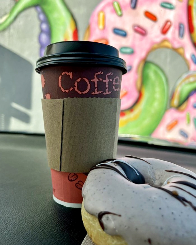 Coffee and donut—a pairing as timeless as Bogart and Bacall. The cup sleeve protects fingers while colorful donut art watches approvingly from the wall.