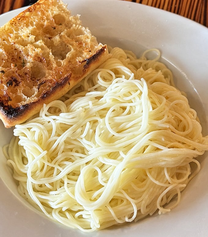Simple pasta with garlic bread – proof that sometimes the most basic combinations are the most satisfying. Comfort food speaks a universal language.