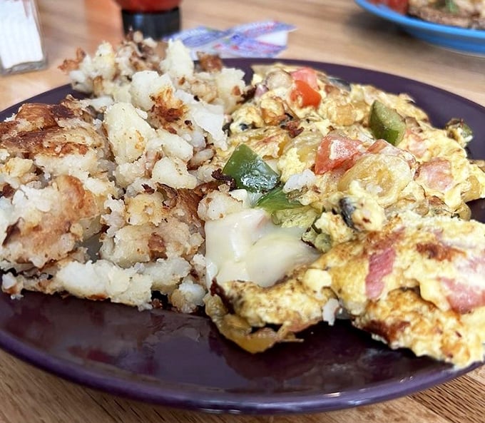 An omelet that actually contains its fillings instead of losing them on the plate—a small miracle in the breakfast universe.