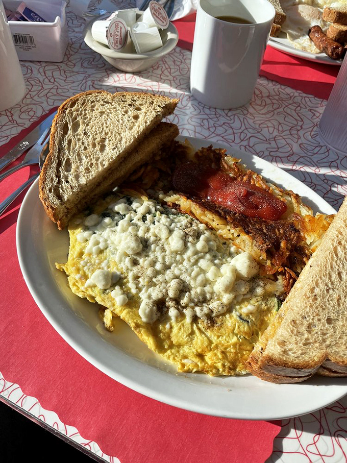An omelet that's seen things—namely cheese, bacon, and possibly your future happiness. Toast soldiers stand ready at the perimeter.