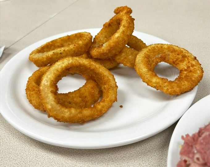 Golden, crispy onion rings that shatter with each bite. These aren't just sides—they're the supporting actors that deserve their own Oscar. 