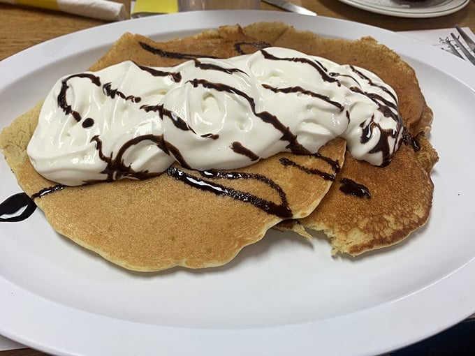 Pancakes that don't need to be photographed to be memorable—they just need to be eaten. That whipped cream and chocolate drizzle is the breakfast equivalent of a standing ovation.