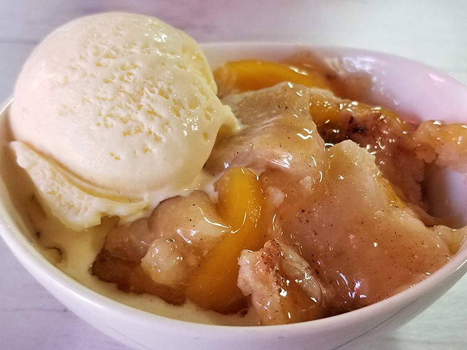Peach cobbler that doesn't just satisfy your sweet tooth—it tells it to sit down and stay awhile. That scoop of vanilla? Non-negotiable.