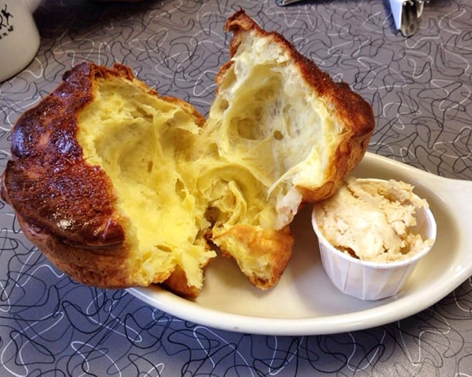 This popover isn't just baked—it's dramatically inflated like it's auditioning for a bread commercial, with a hollow center perfect for melting butter.
