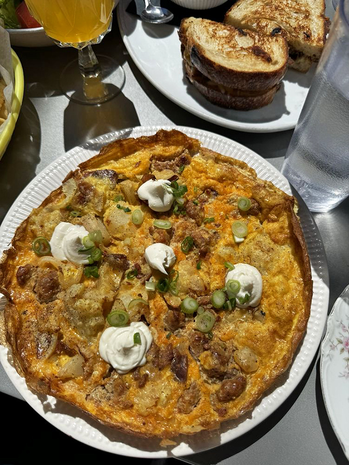 This potato frittata is what breakfast dreams are made of—a golden canvas of eggs, potatoes, and cheese topped with dollops of sour cream.