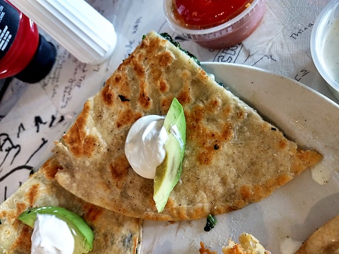 A quesadilla that doesn't mess around—crispy, cheese-laden, and adorned with fresh avocado and sour cream. Tex-Mex simplicity elevated to an art form.