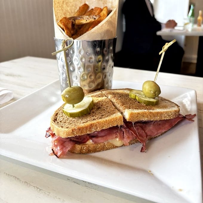 The sandwich that bridges breakfast and lunch—pastrami nestled between toasty rye with those house-made fries standing at attention in their metal sentry.