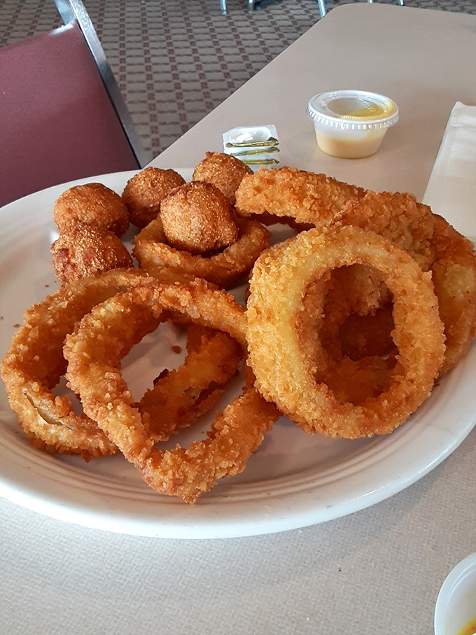 Onion rings and hush puppies that deserve their own fan club – golden-fried perfection that makes sharing a true test of character.