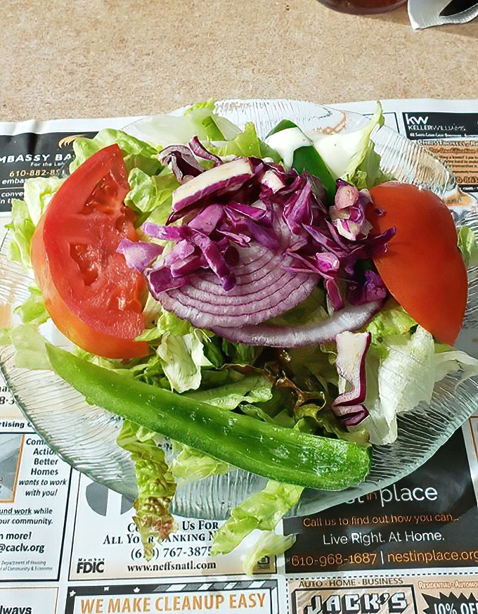 Even the side salad gets respect here – crisp lettuce, vibrant tomatoes, and purple onion slices that add color to your obligatory vegetable intake.