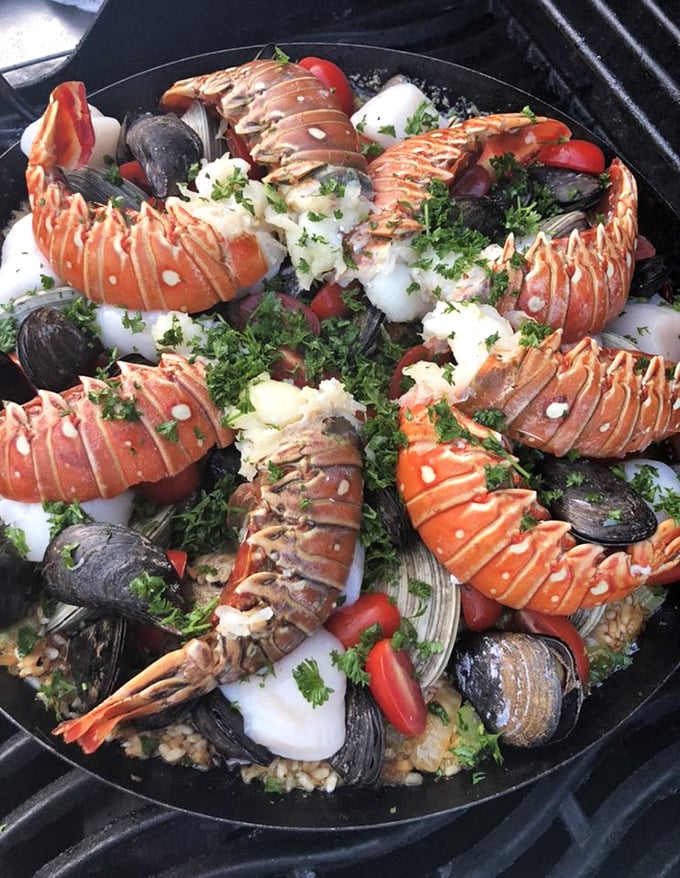 A seafood paella that looks like it should have its own ZIP code—a neighborhood of lobster tails, mussels, and clams living harmoniously on a bed of saffron-kissed rice.