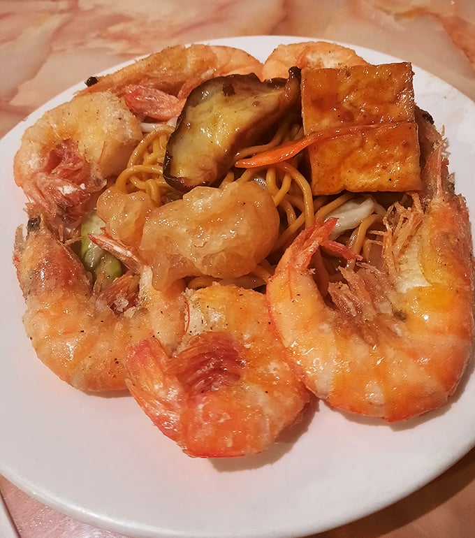 A plate that tells the story of buffet strategy—jumbo shrimp, noodles, and tofu arranged in that "eyes bigger than stomach" optimism we all know too well.