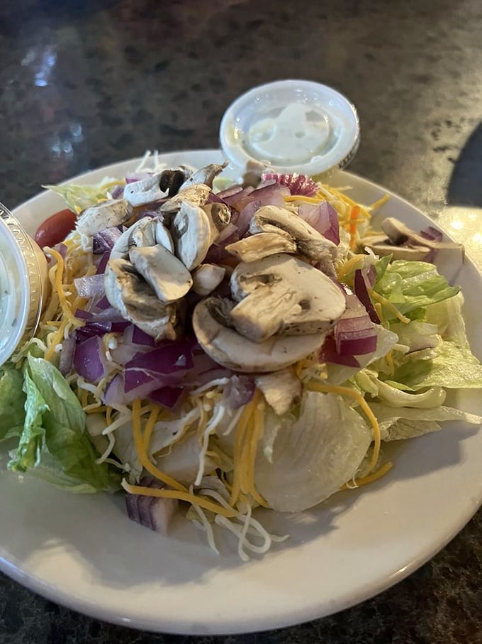 Even the side salad gets special attention—proof that Poor Richard's understands balance is adding cheese and fresh mushrooms to your lettuce.