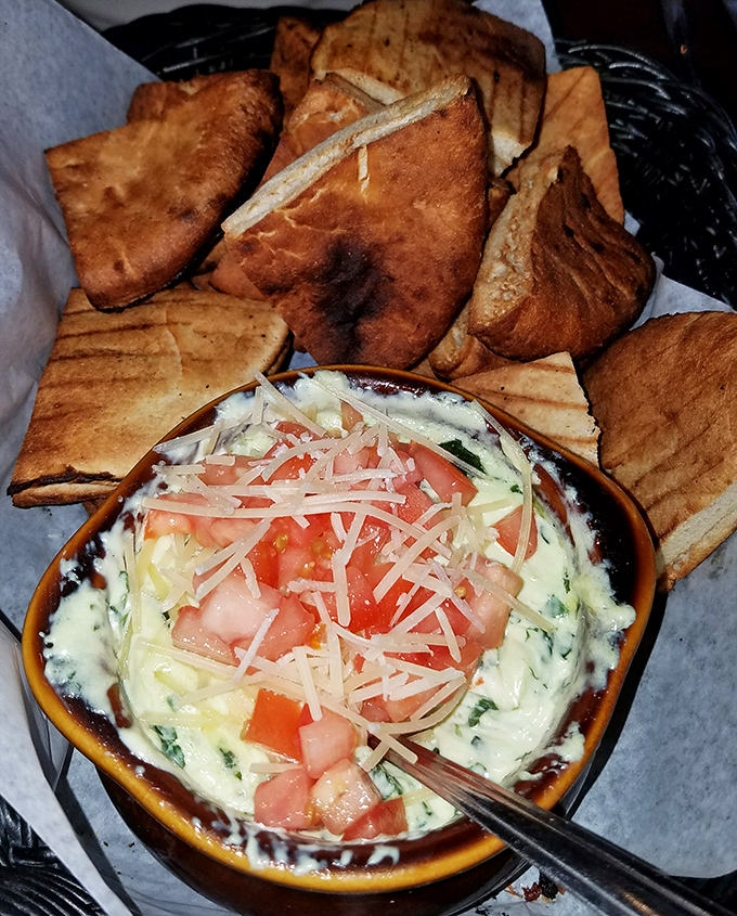 Spinach and artichoke dip that demands to be shared, yet inspires selfish thoughts—paired with perfectly toasted bread for maximum scooping efficiency.