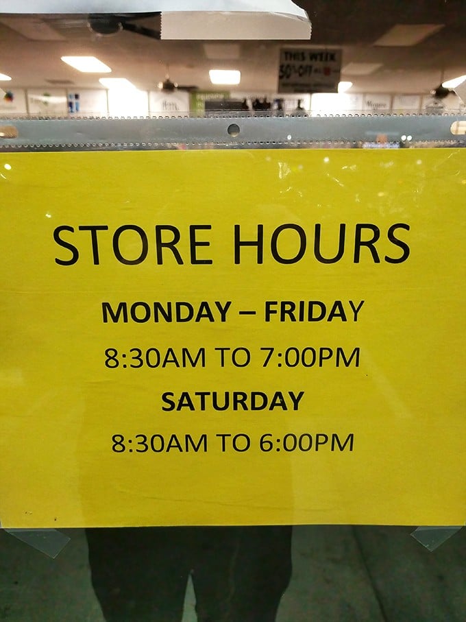 The yellow store hours sign—memorize these times like sacred text if you want first dibs on fresh merchandise.