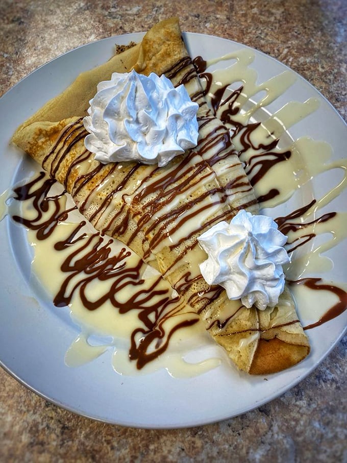 A crepe that's dressed for dessert but accepted into the breakfast club. Those chocolate drizzles aren't just decoration—they're permission to indulge.