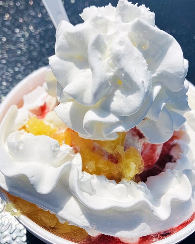 Behold the strawberry pineapple sundae—a mountain of whipped cream atop fruity treasures hiding below, like a delicious geological wonder waiting to be excavated.