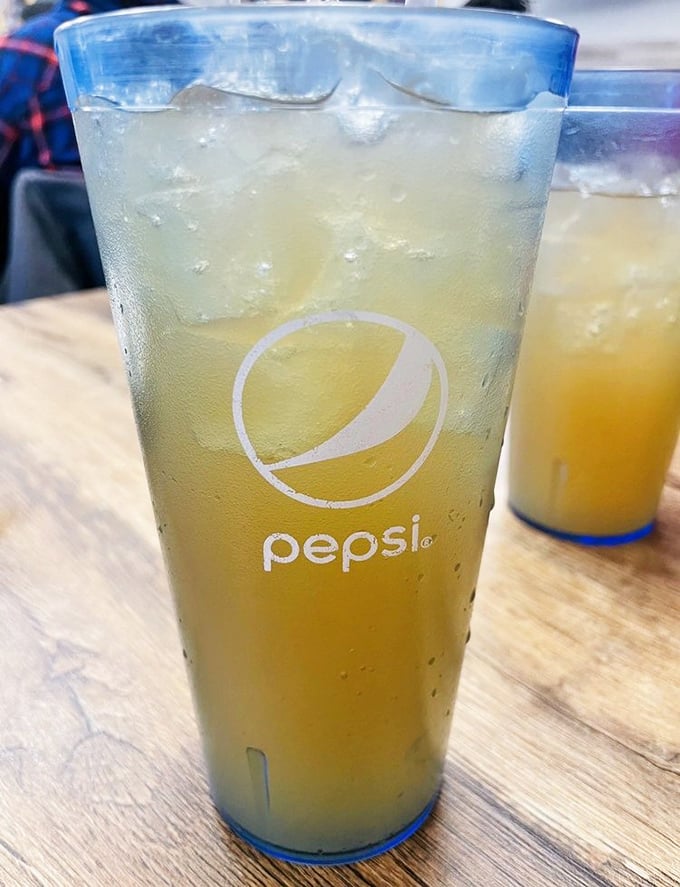 Sweet tea in a Pepsi glass—the unofficial state beverage of the South arrives properly chilled and ready to cut through rich flavors.
