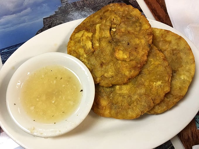Tostones with their garlic dipping sauce—proof that sometimes the best things in life are fried twice.