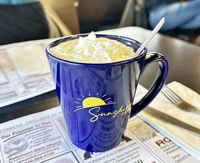 Their signature blue mug doesn't just hold coffee – it cradles liquid sunshine topped with a cloud of whipped cream.