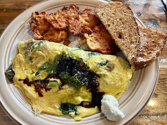 This isn't just an omelet—it's a vegetable delivery system disguised as breakfast indulgence, with toast standing by for necessary mopping duties. 