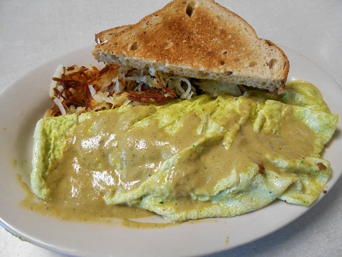 This isn't just an omelet—it's a golden envelope delivering a love letter of ingredients beneath a blanket of cheese sauce that means business.
