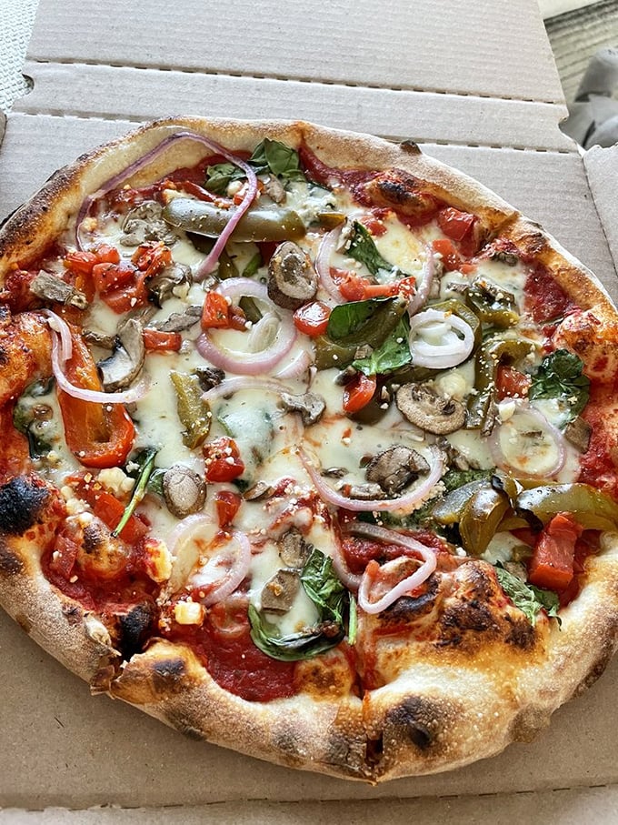 A veggie pizza so loaded it counts as a farmer's market visit—mushrooms, peppers, and onions in perfect harmony.