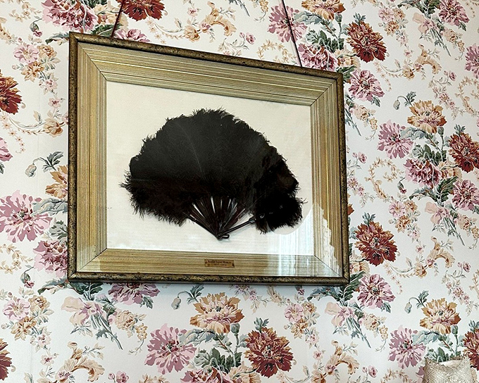 A Victorian lady's feather fan—the 19th-century equivalent of air conditioning with the added bonus of flirtatious possibilities behind floral wallpaper.