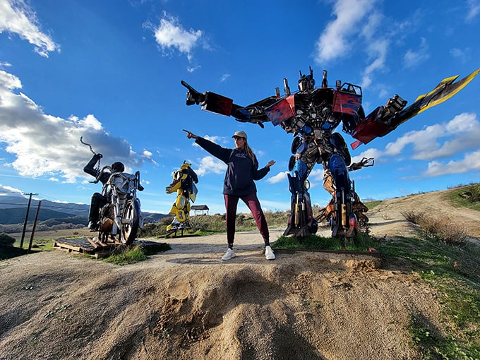 Modern meets metal as a visitor strikes a pose with sculptures that transform desert wandering into a sci-fi adventure.