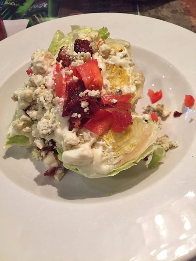 The wedge salad offers a refreshing crunch beneath layers of bacon, tomato, and blue cheese—proof that vegetables can be indulgent too.