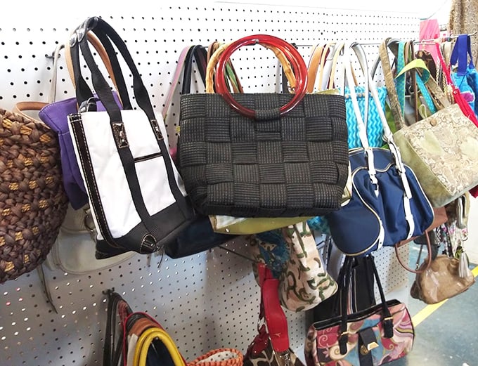Handbag heaven hanging from pegboard paradise – from woven summer totes to structured leather purses, arm candy awaits at a fraction of retail prices.