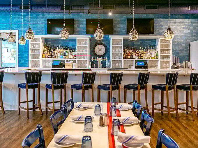 The bar area combines coastal blues with elegant lighting, creating the perfect spot to sip something cold while debating which seafood treasure to order next.