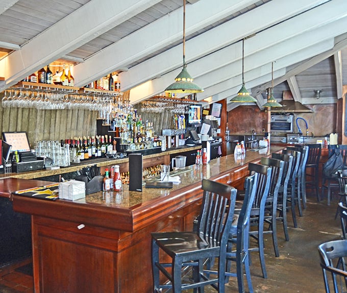 The bar area balances rustic charm with coastal sophistication – where locals and tourists alike discover that seafood tastes better with a side of ocean breeze.