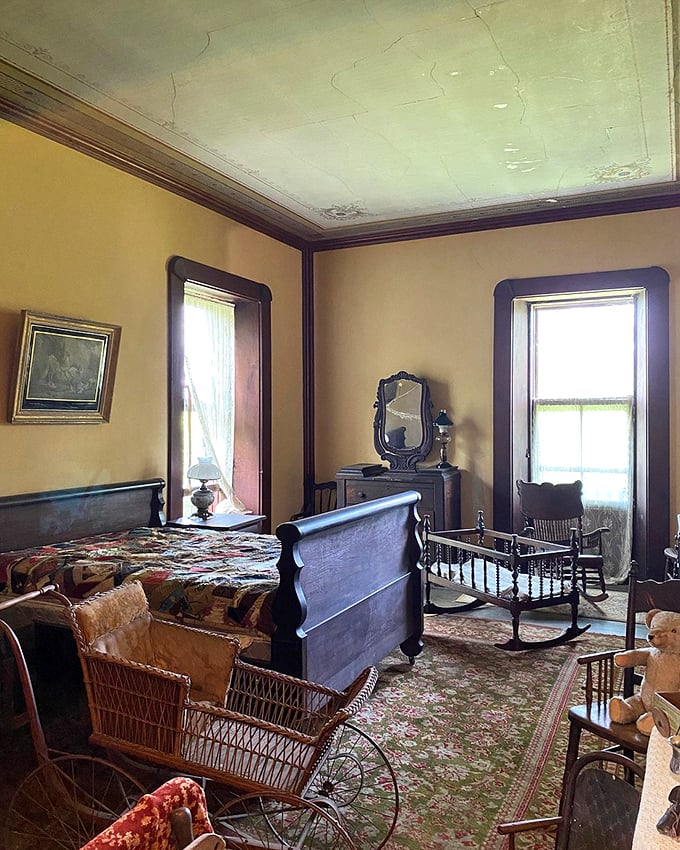 This bedroom suite features a cradle and wicker baby carriage—childcare solutions from an era when "sleep training" meant hoping for the best.
