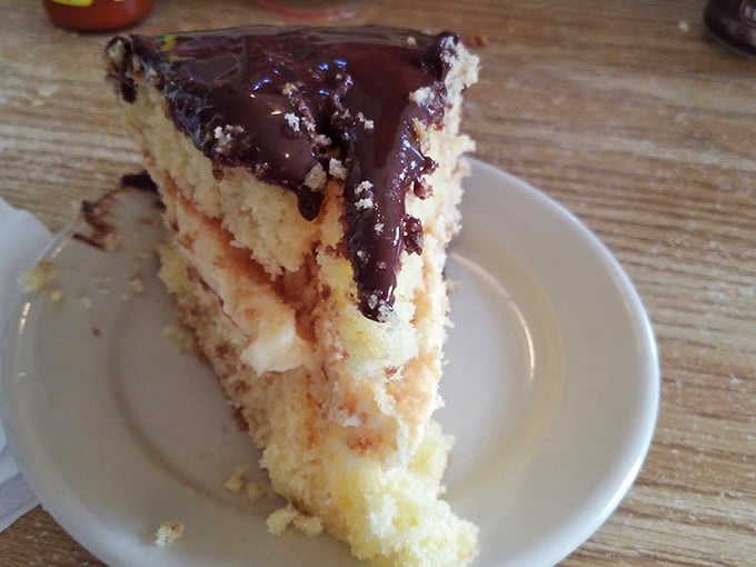 Layer upon layer of sweet conspiracy—this Boston cream cake isn't just dessert, it's proof that happiness can be served on a small white plate.
