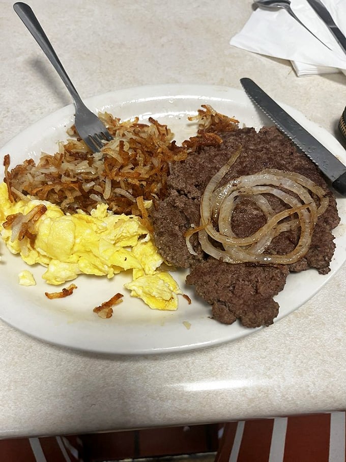 The classic hamburger steak platter—where eggs and meat unite in a breakfast symphony that would make your cardiologist wince and your taste buds applaud.