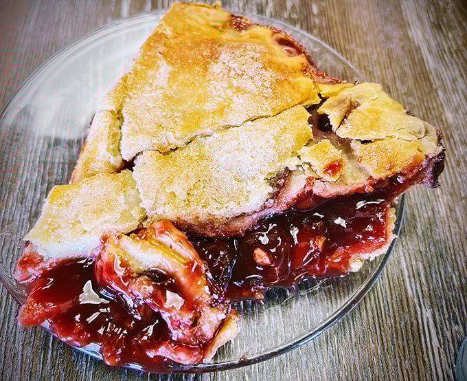 Cherry pie that strikes the perfect balance between sweet and tart – the ruby filling peeking through golden crust like a delicious geological formation.