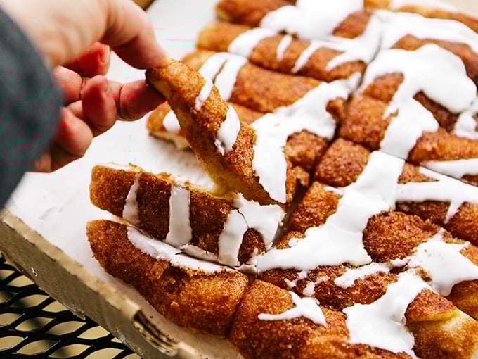 Cinnamon sticks drizzled with icing – dessert disguised as bread, proving that the best endings are sweet, warm, and slightly messy.