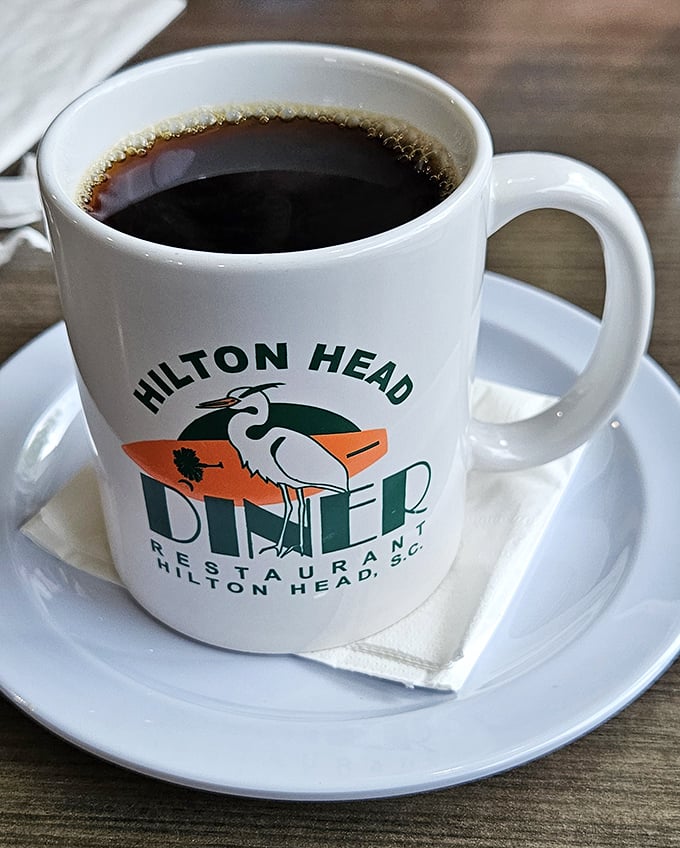 Coffee served in a mug that means business, emblazoned with the diner's iconic logo—because serious breakfast requires serious caffeine.