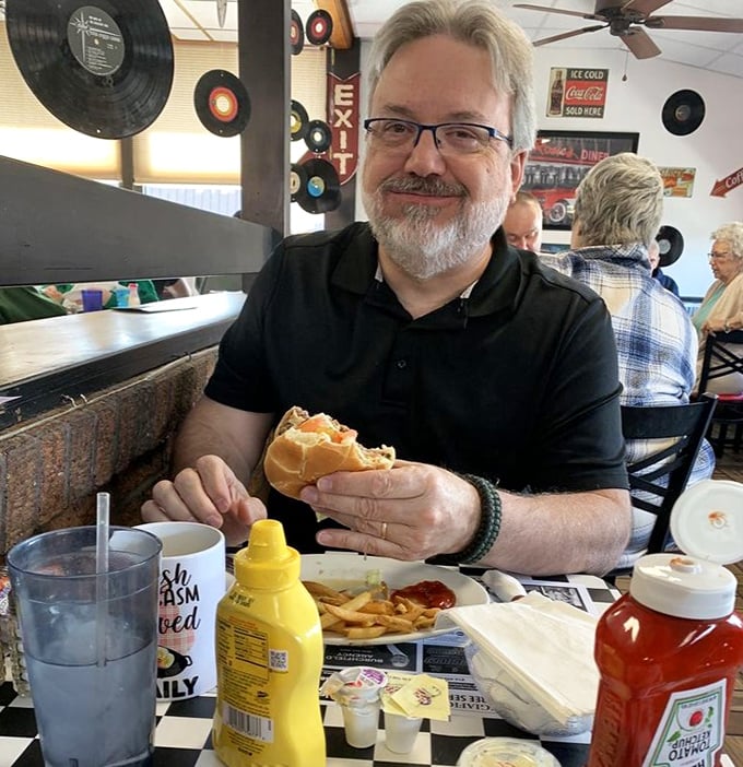 The diner's unofficial mascot can't help smiling—he's halfway through a burger that makes fast food chains look like they're not even trying.